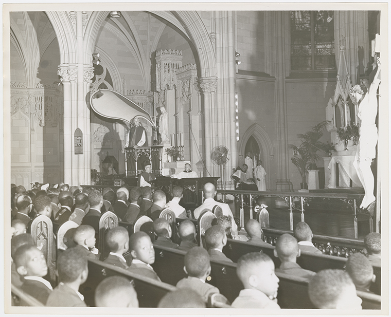 Priest delivering sermon during a religious service held at St. Charles ...