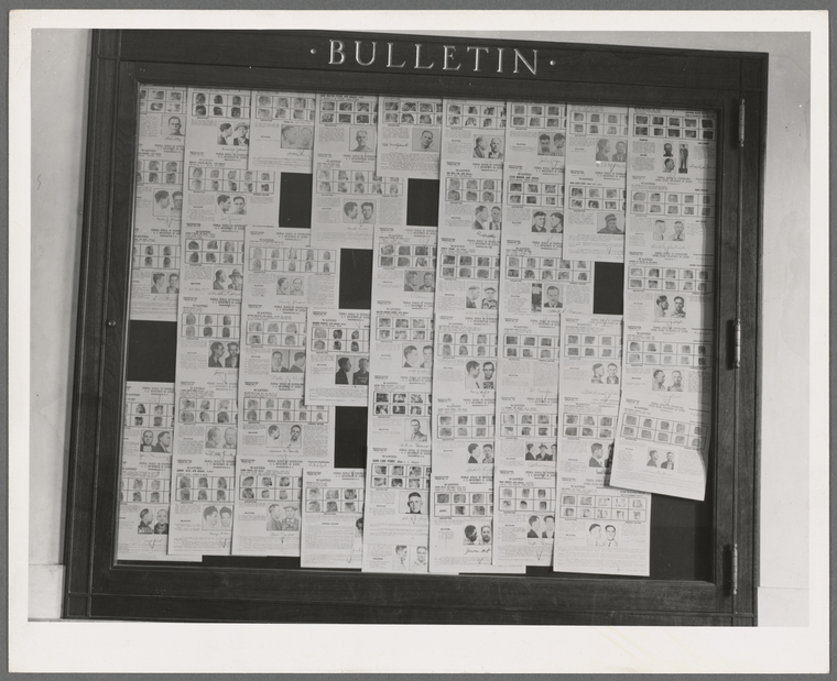 Bulletin board in post office showing a large collection of "wanted men ...