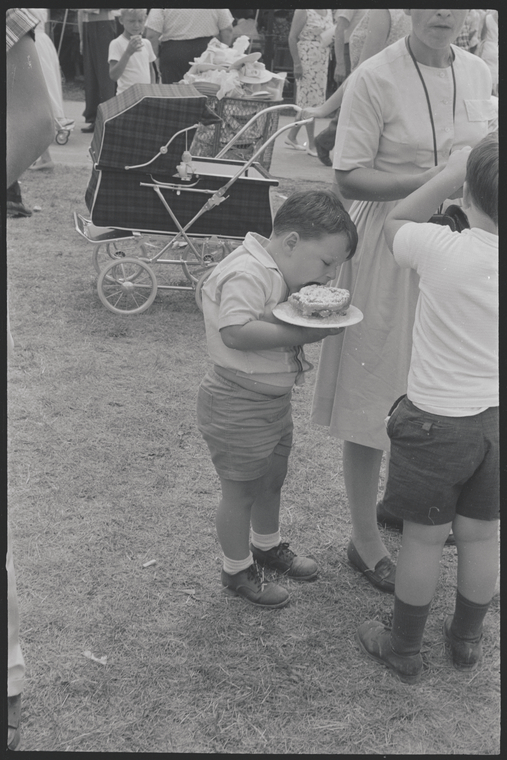 Boy eating funnel cake at fair - NYPL Digital Collections