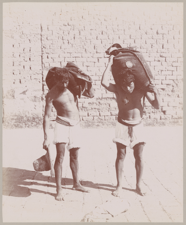 Two men carrying heavy loads on their shoulders - NYPL Digital Collections