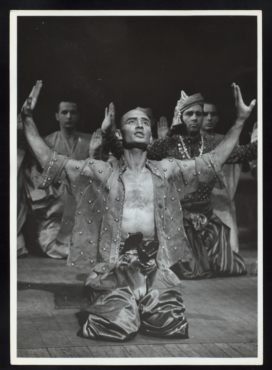 Production shot of cast at end of Act I, Yul Brynner kneeling, arms ...