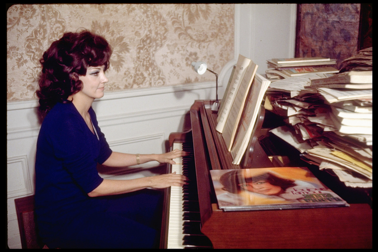 Opera singer Anna Moffo playing the piano in the music room of her ...
